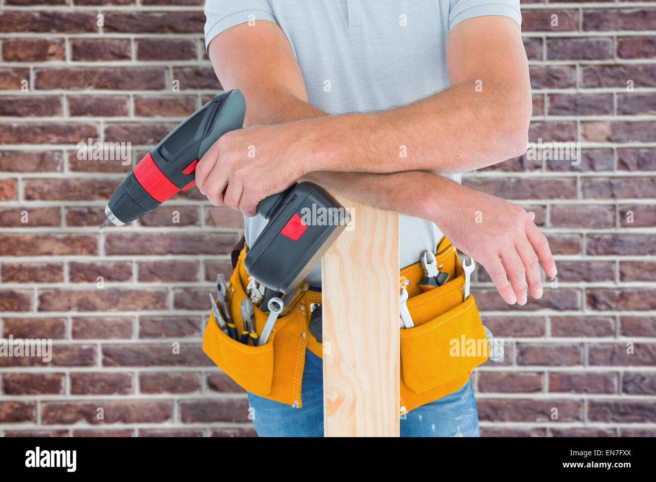 Composite image of midsection of male carpenter with power drill and ...