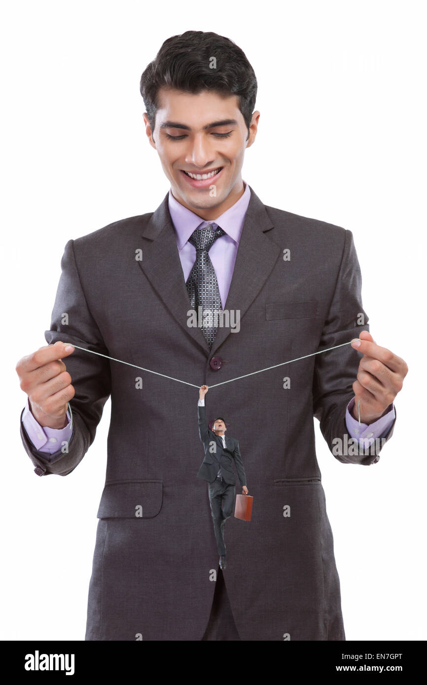 Businessman holding string from which another businessman hangs Stock ...