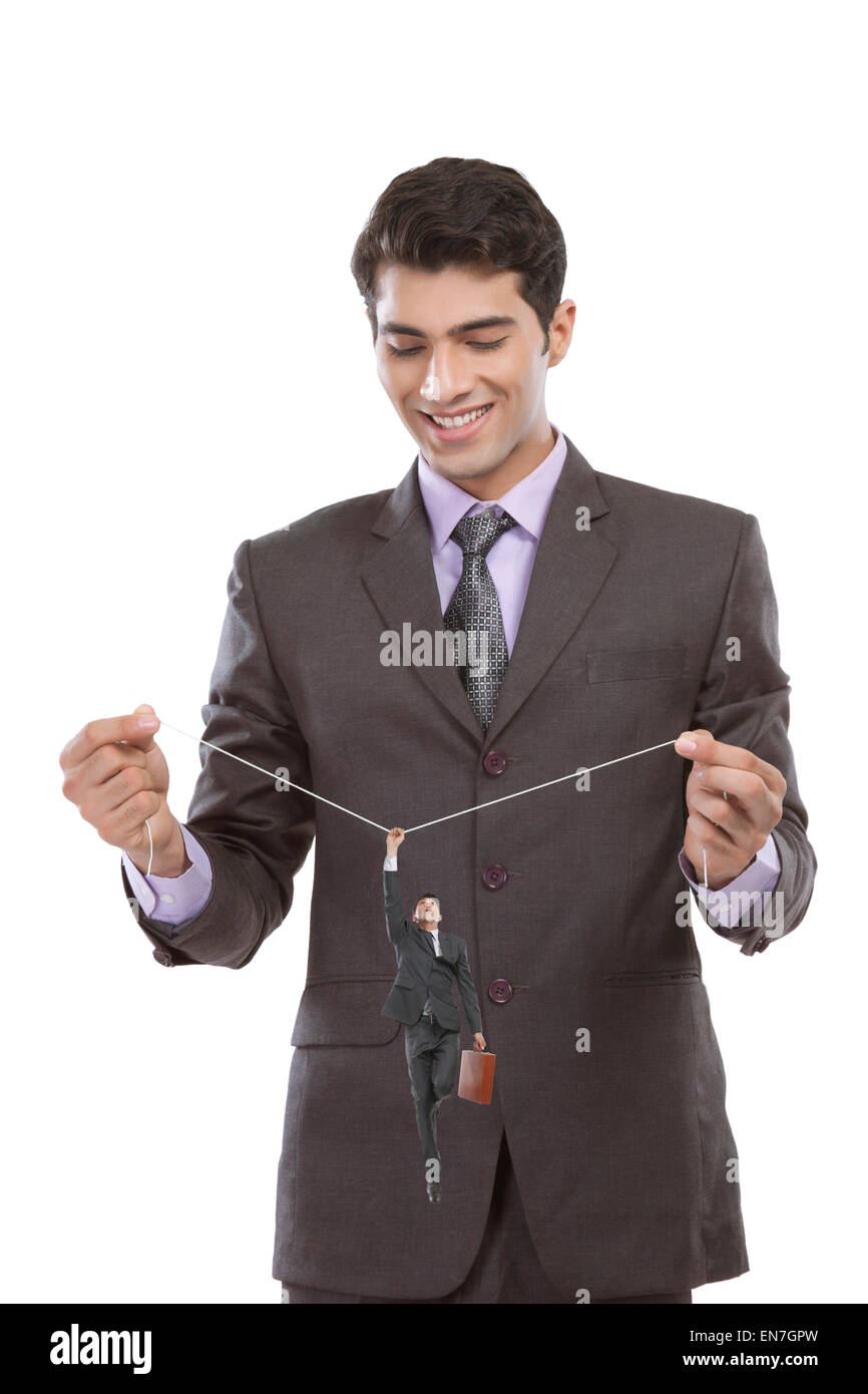 Businessman holding string from which another businessman hangs Stock ...