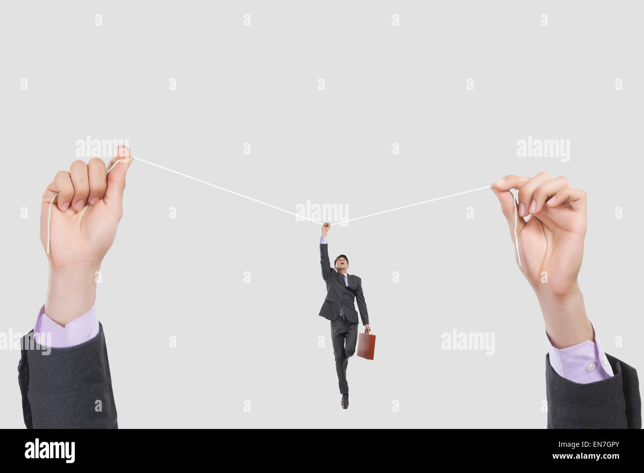 Businessman hanging from string Stock Photo - Alamy