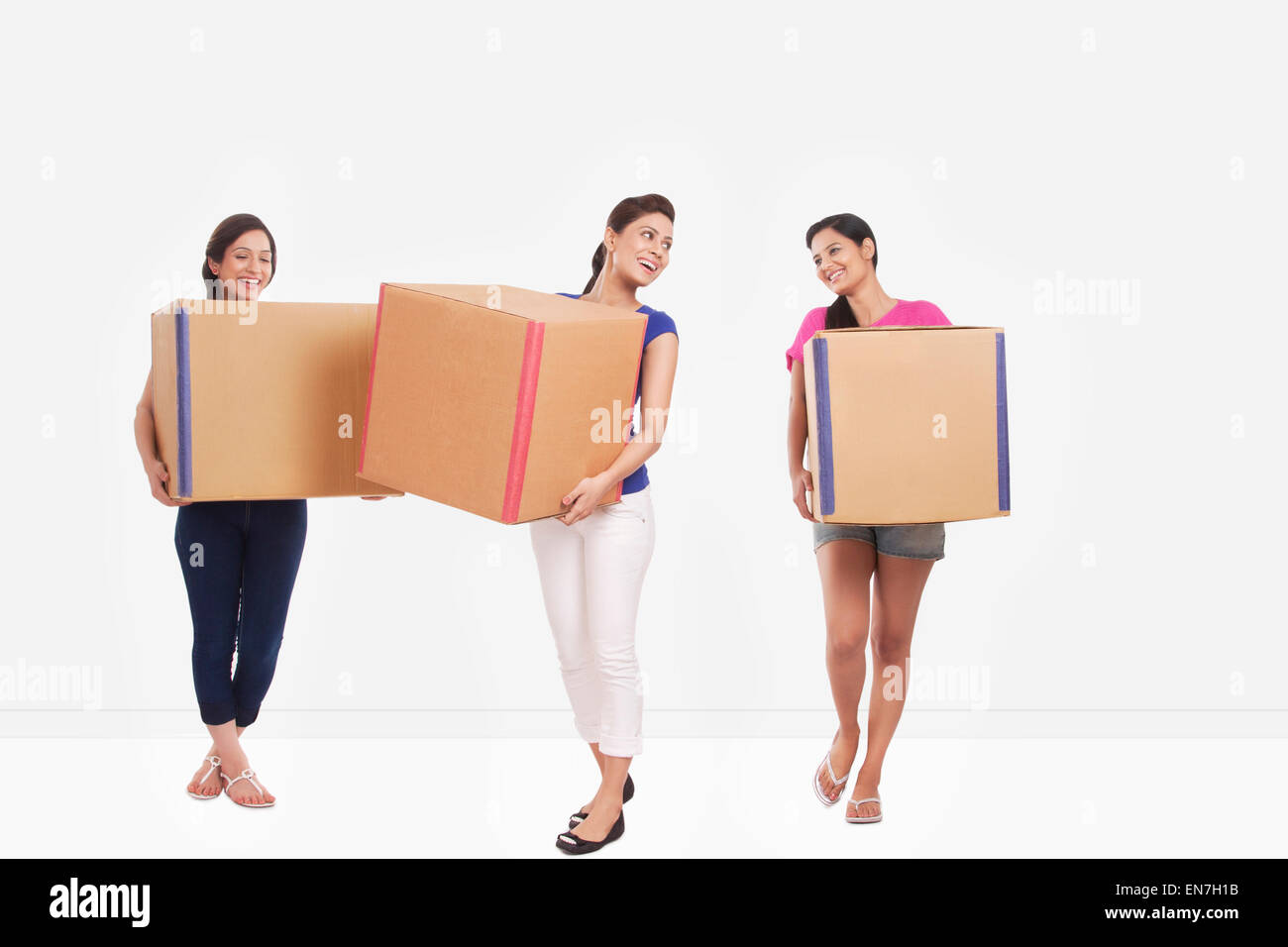 Young women carrying cartons Stock Photo - Alamy