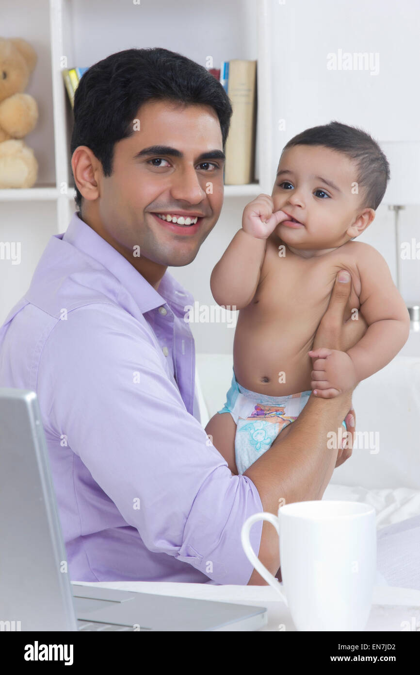 Portrait of man holding baby Stock Photo - Alamy