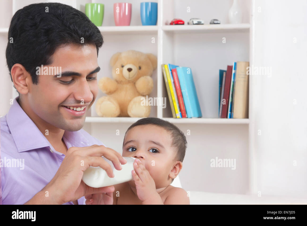 Man feeding baby with milk from bottle Stock Photo - Alamy