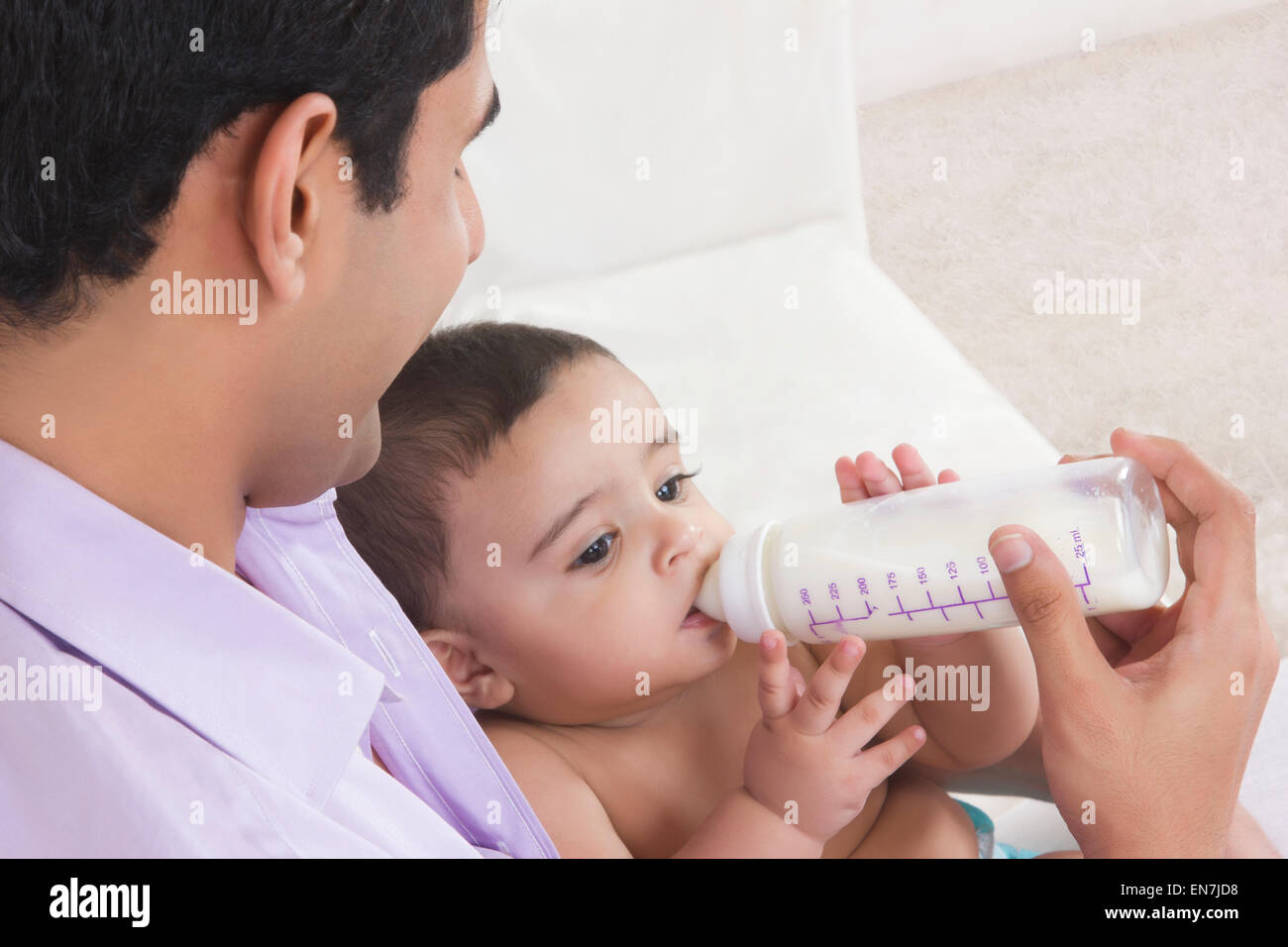 Man feeding baby with milk from bottle Stock Photo - Alamy