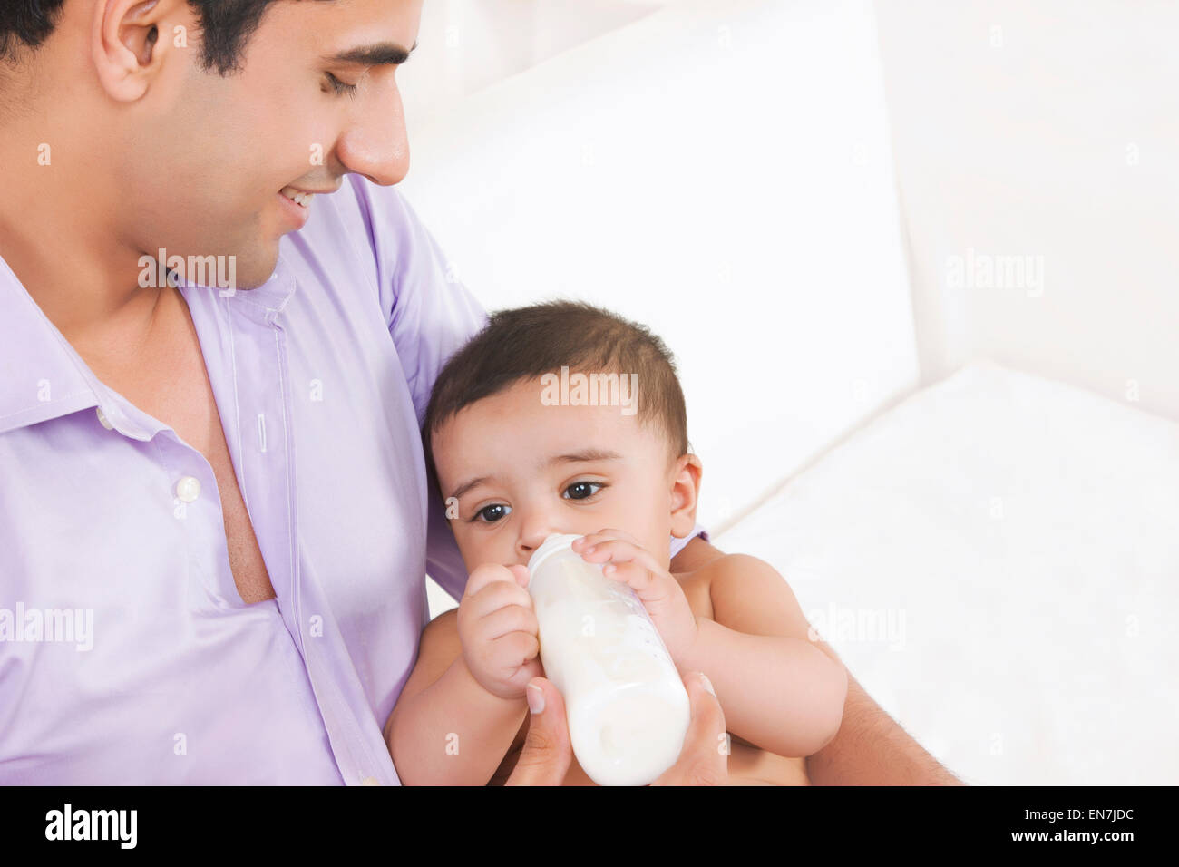 Man feeding baby with milk from bottle Stock Photo - Alamy