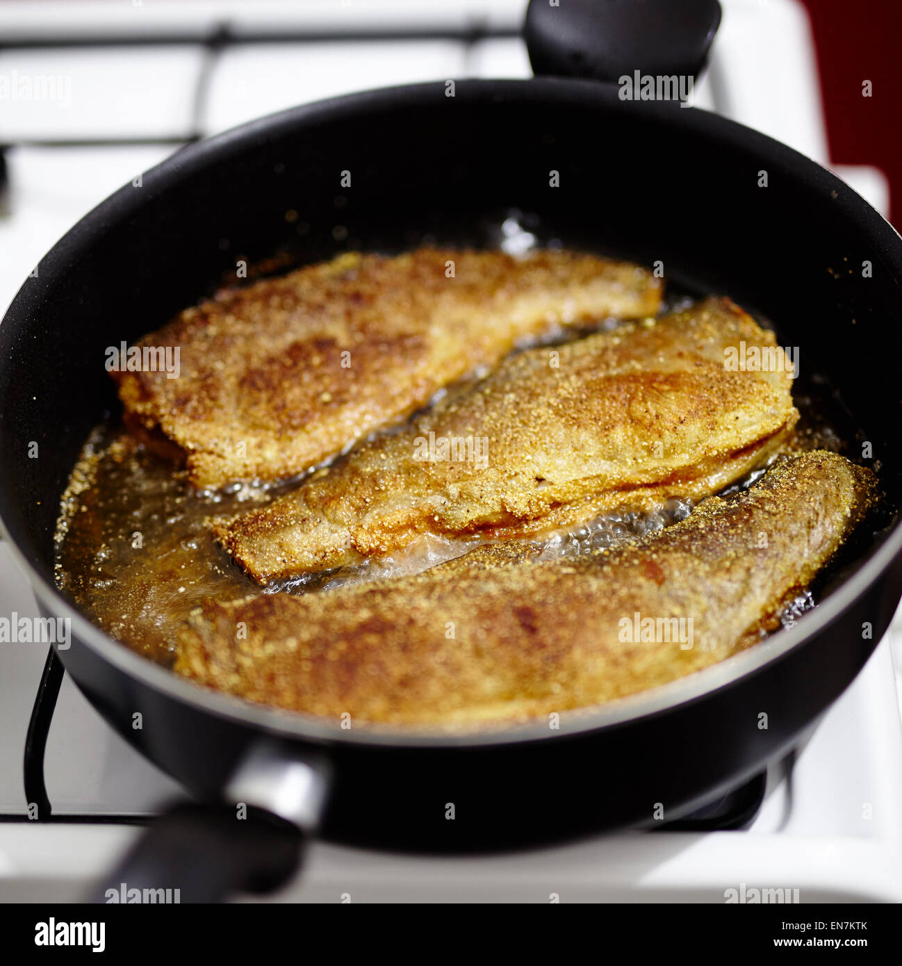 Preparing fried trout covered with corn flour in a pan Stock Photo - Alamy