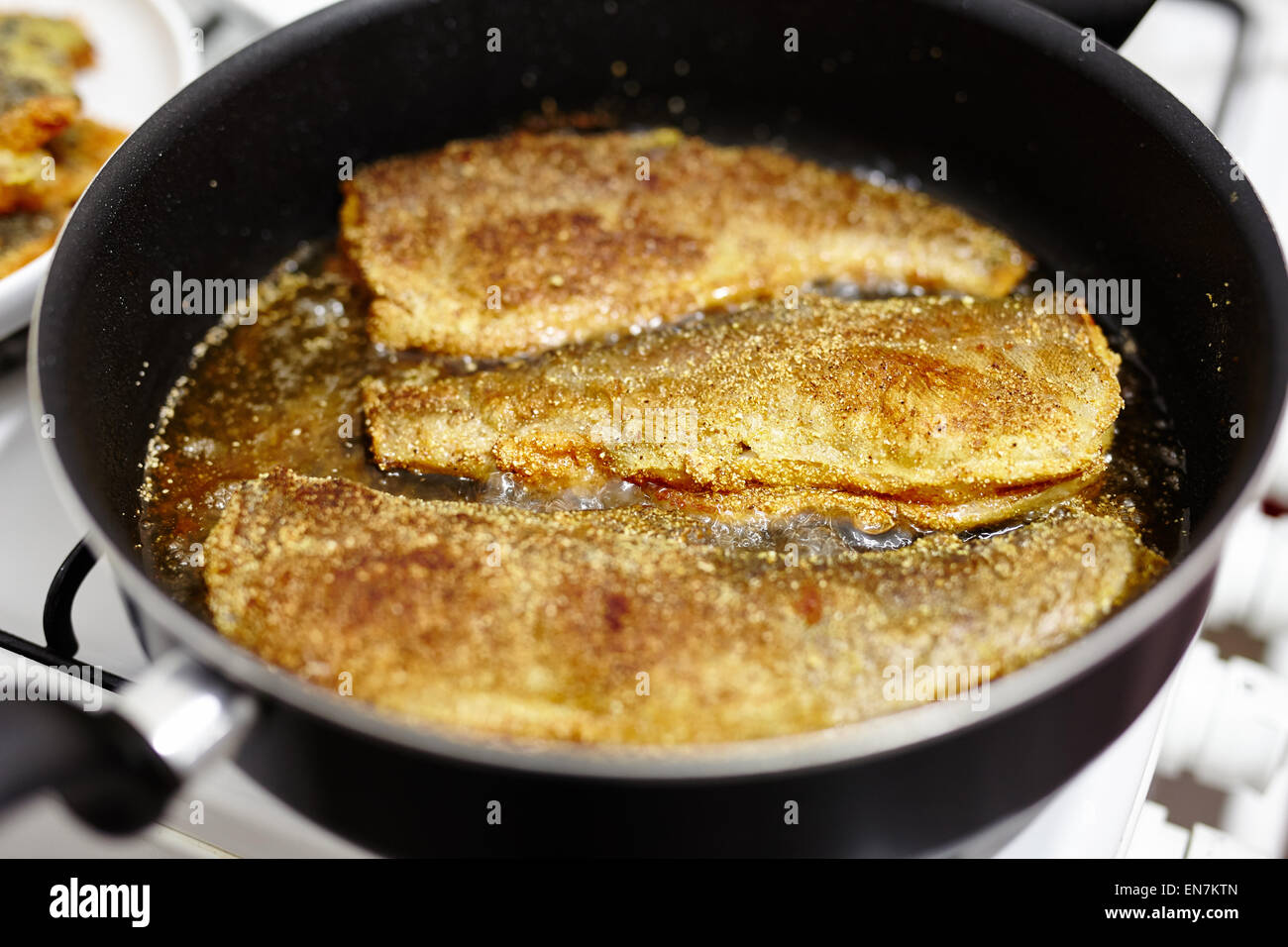 Preparing fried trout covered with corn flour in a pan Stock Photo - Alamy