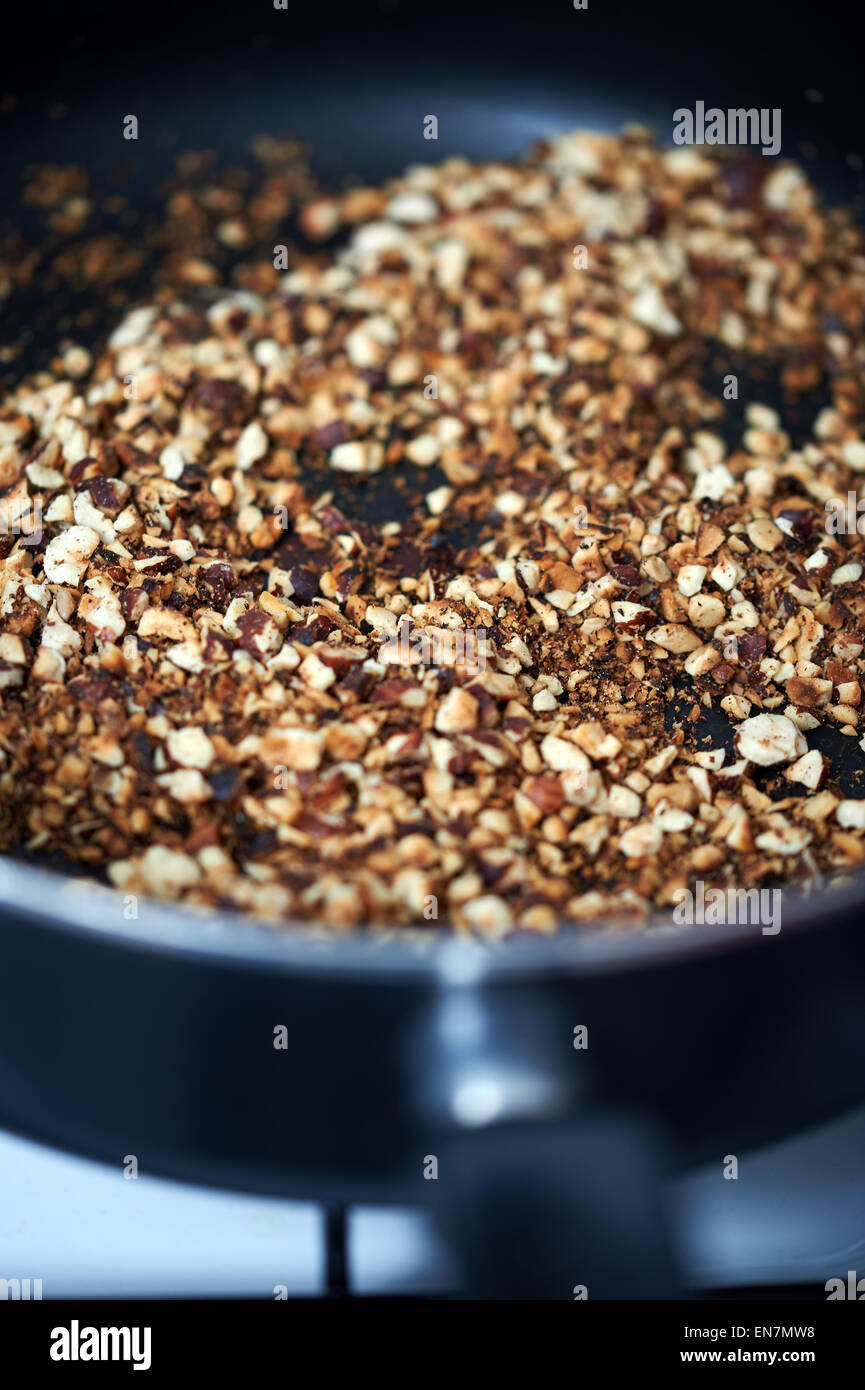 Ground nuts mix dry frying in the pan on stove Stock Photo - Alamy