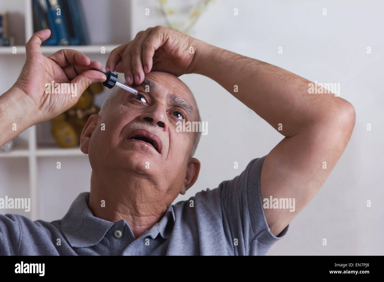 Old man using eye drops Stock Photo - Alamy