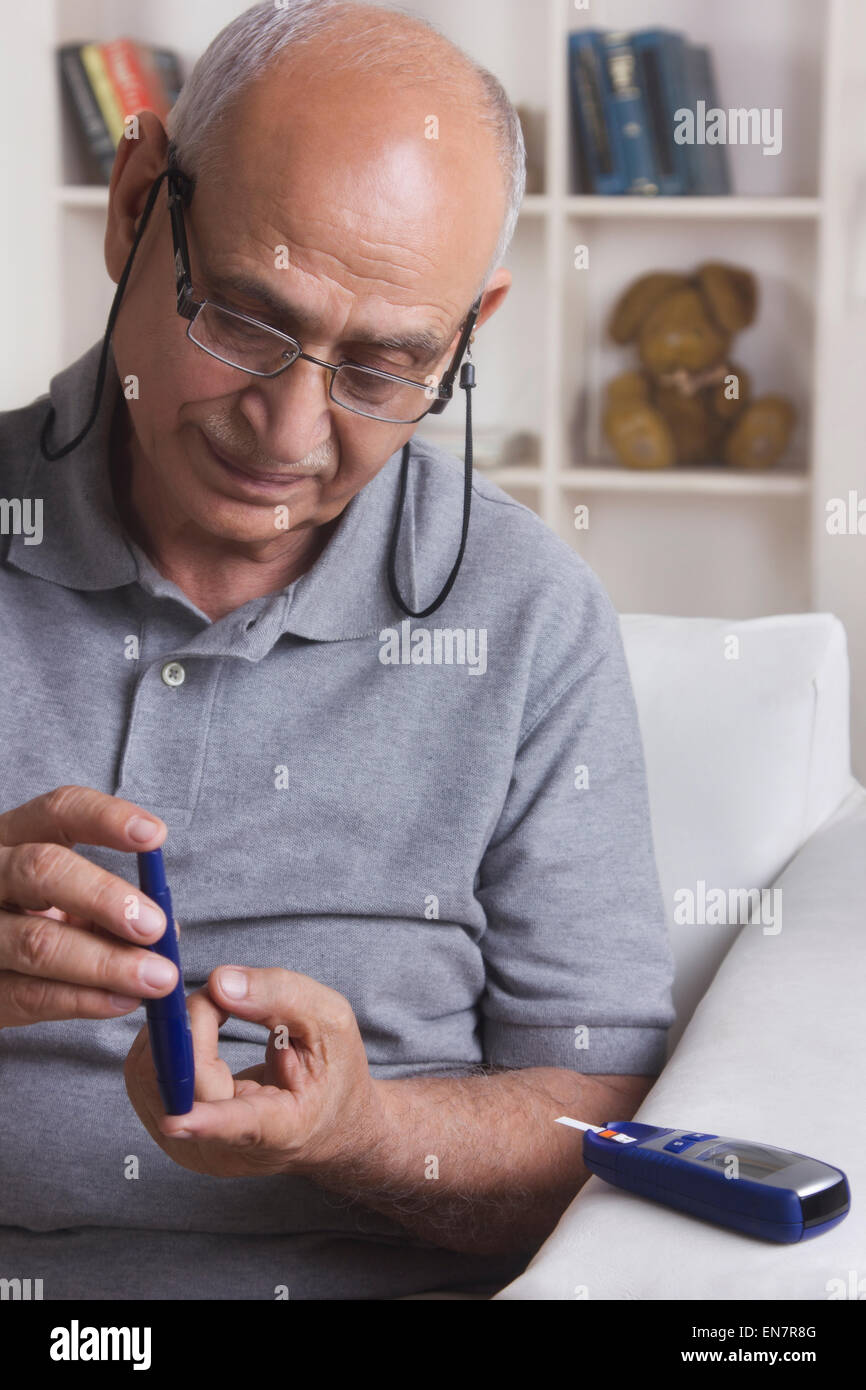 Diabetic old man testing blood sugar Stock Photo - Alamy