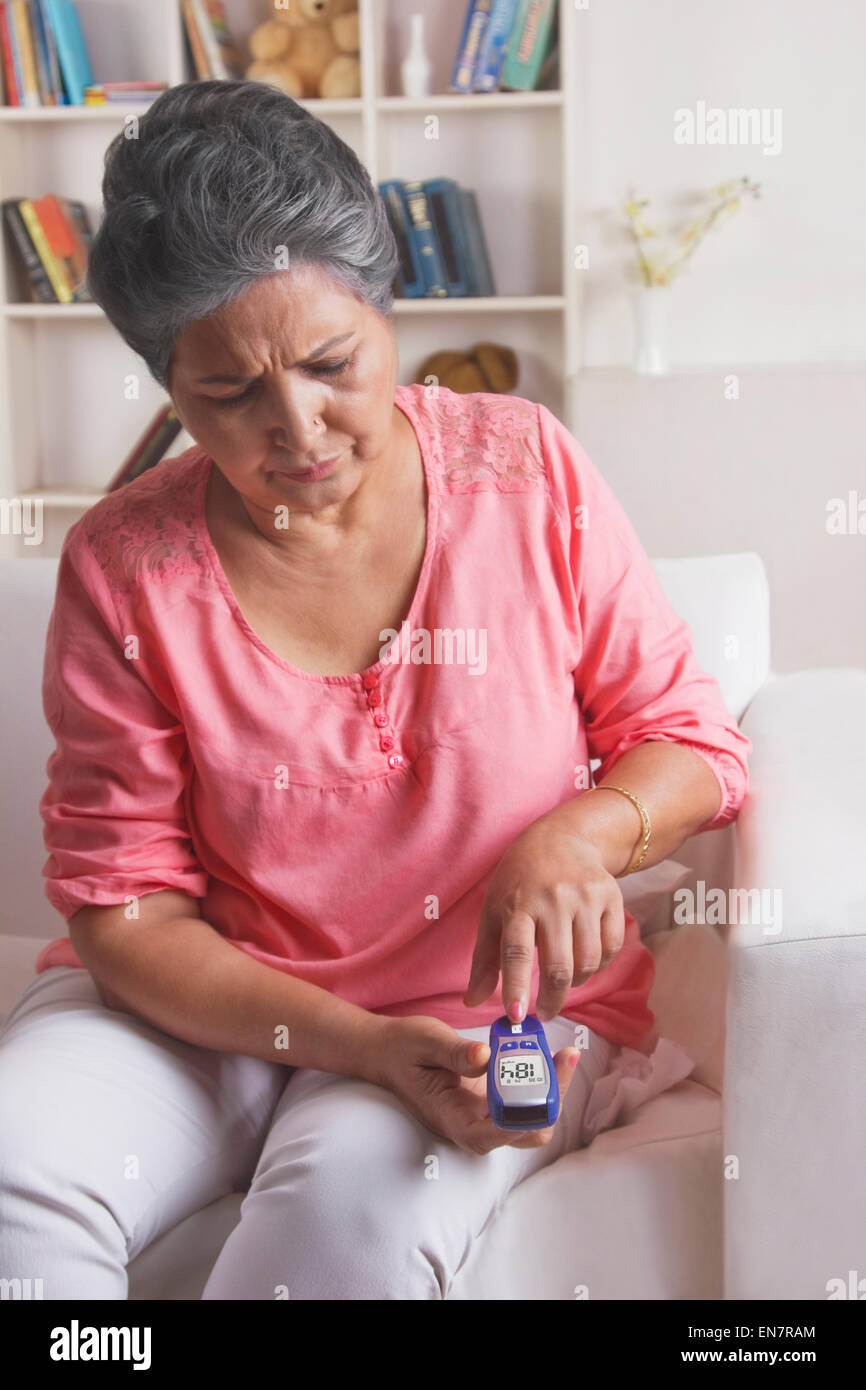 Old woman using glucose meter Stock Photo - Alamy