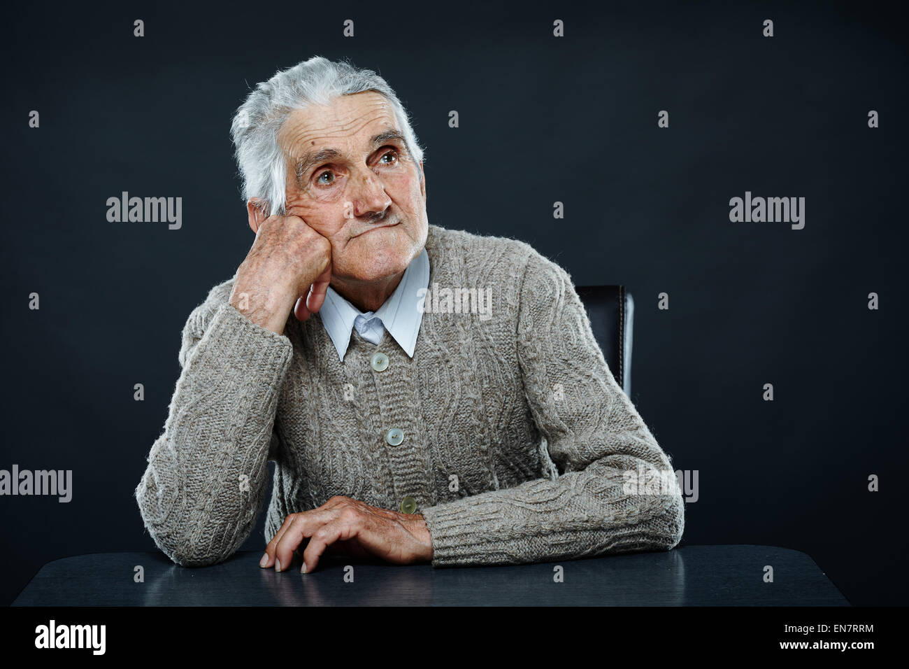 Happy 80 years old man sitting at the desk, studio shot Stock Photo - Alamy