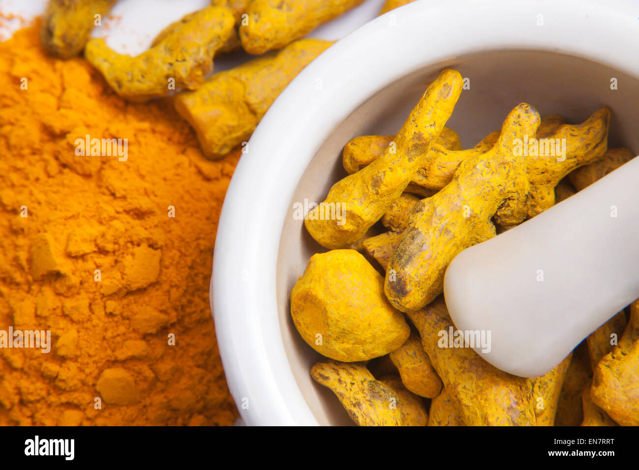 Close-up of turmeric roots in a mortar with turmeric powder Stock Photo ...