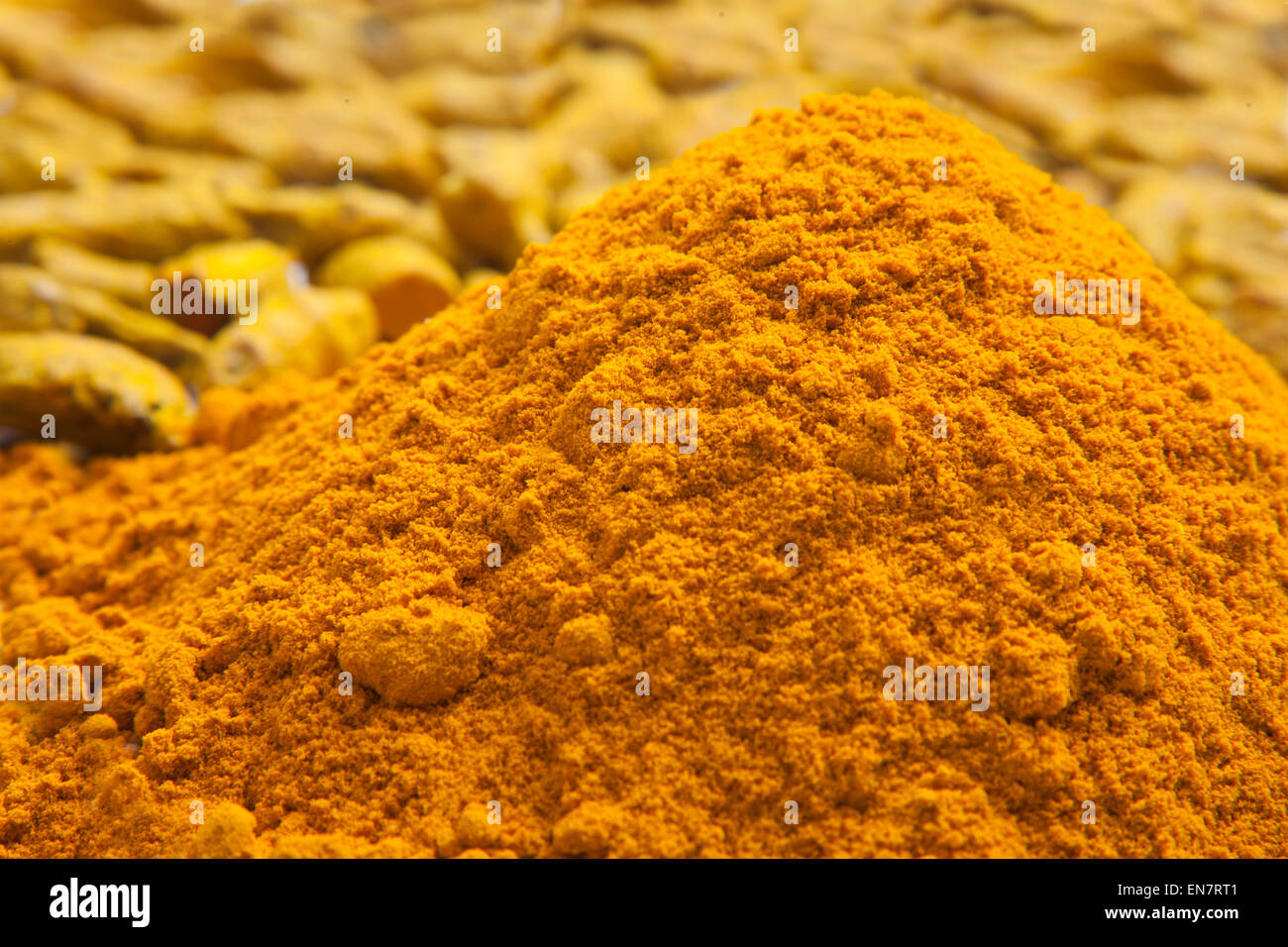 Heap of turmeric powder with tumeric roots on background Stock Photo ...