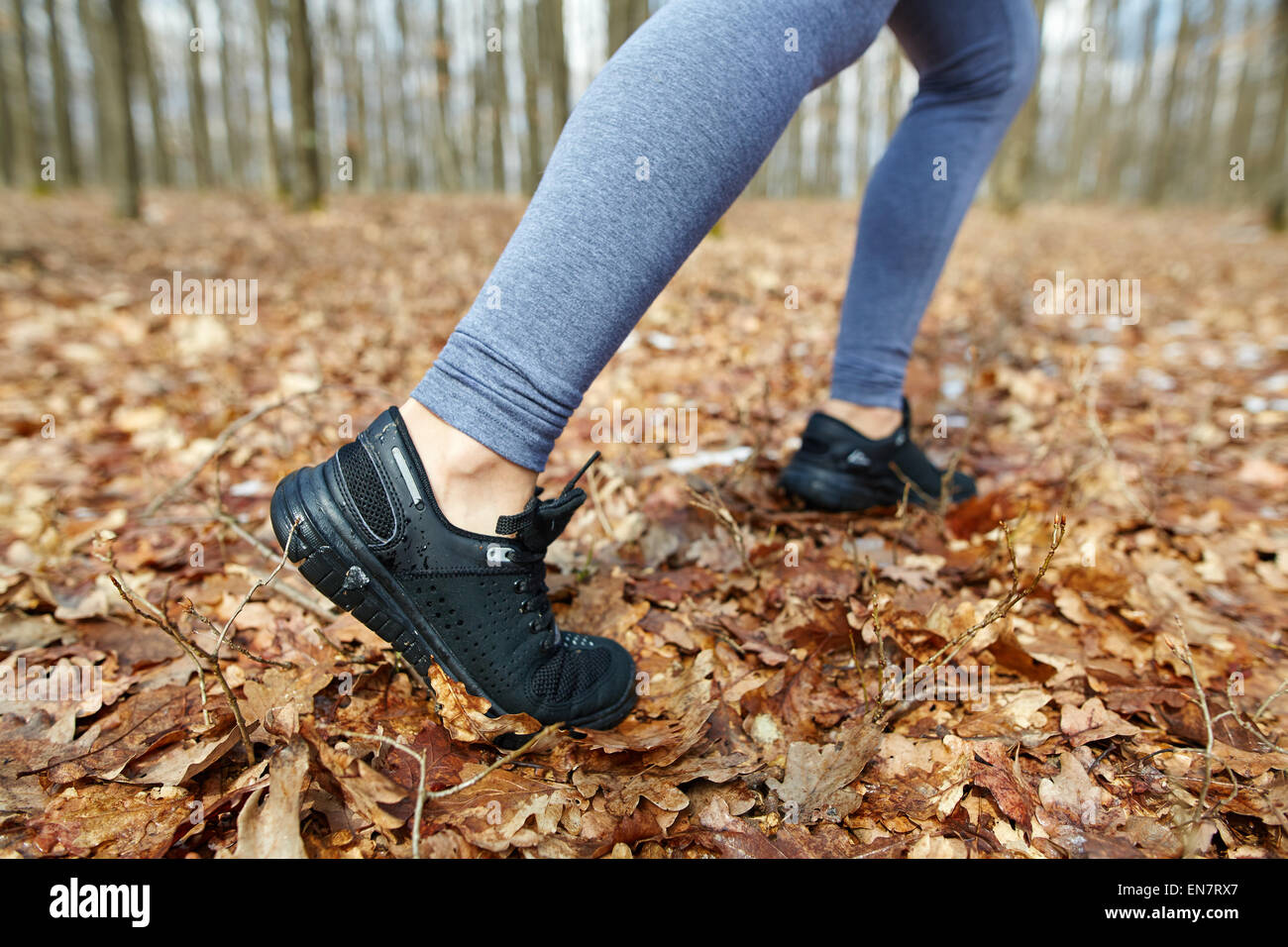 Closeup of a young woman's legs jogging on a trail in the forest Stock ...