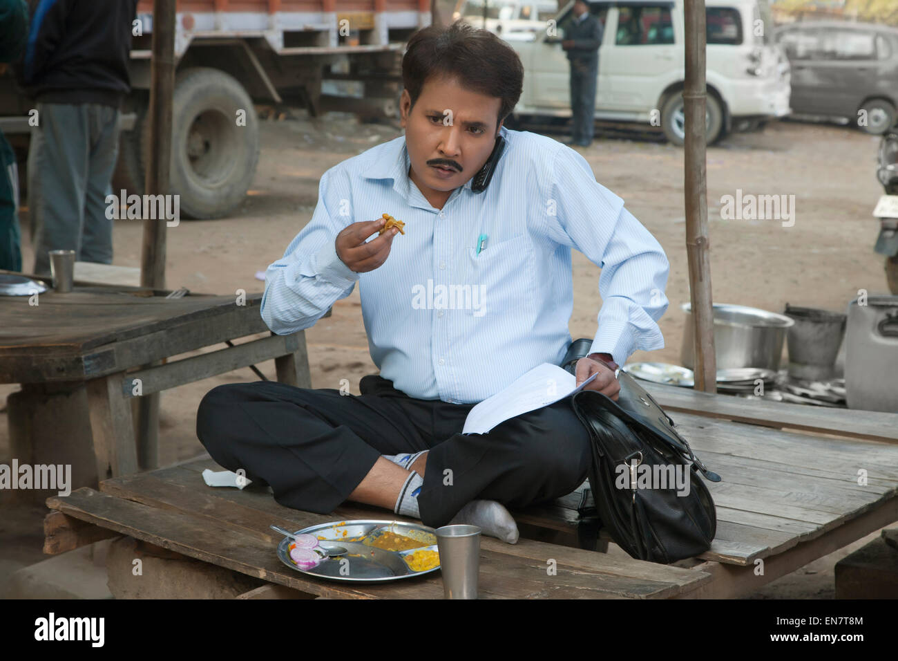 Salesman having lunch and using cell phone Stock Photo - Alamy