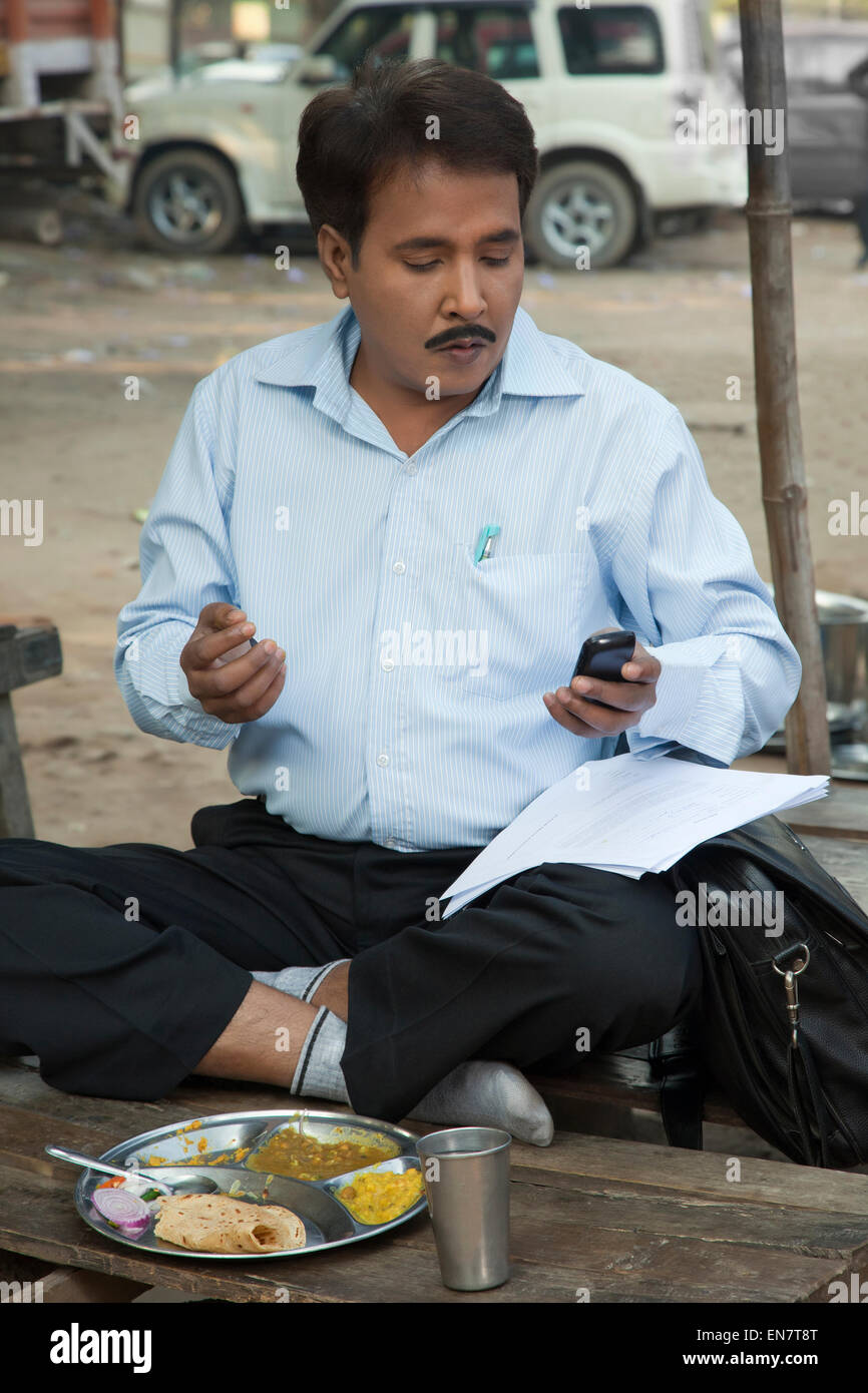 Salesman having lunch and using cell phone Stock Photo - Alamy