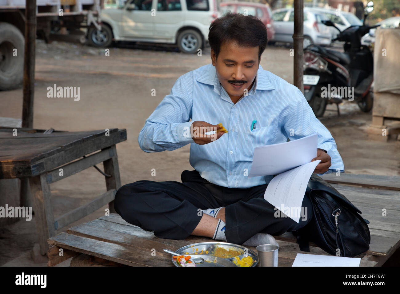 Salesman having lunch and looking into paper work Stock Photo - Alamy