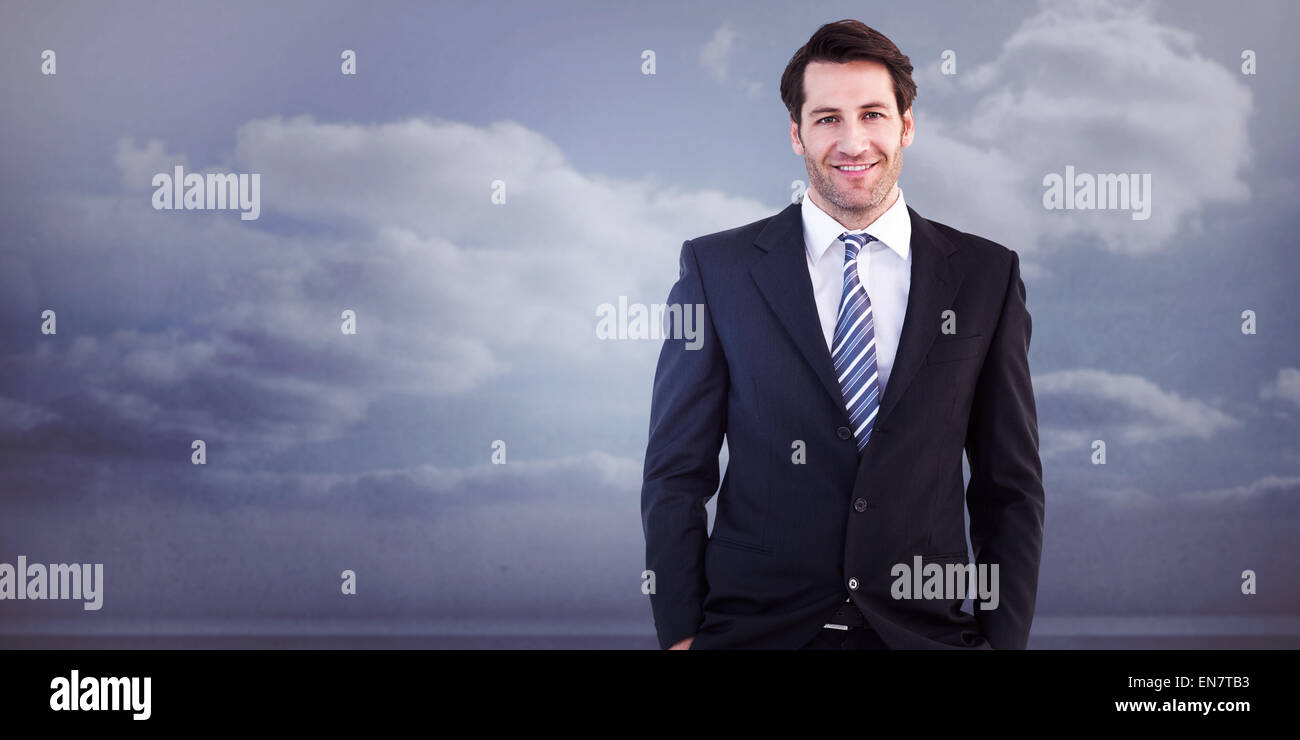 Composite image of smiling businessman standing with hands in pockets ...