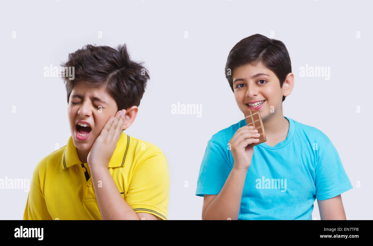 Boy with toothache and eating chocolate Stock Photo - Alamy