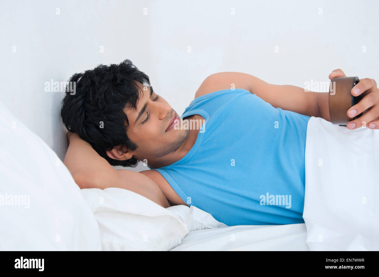 Young man looking at clock Stock Photo - Alamy