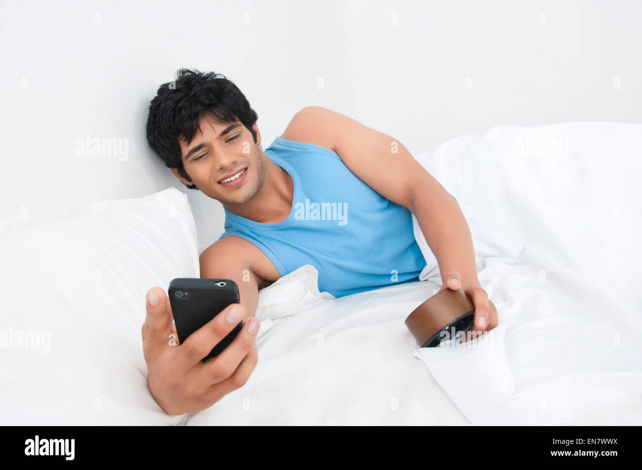 Man looking cell phone bed hi-res stock photography and images - Alamy