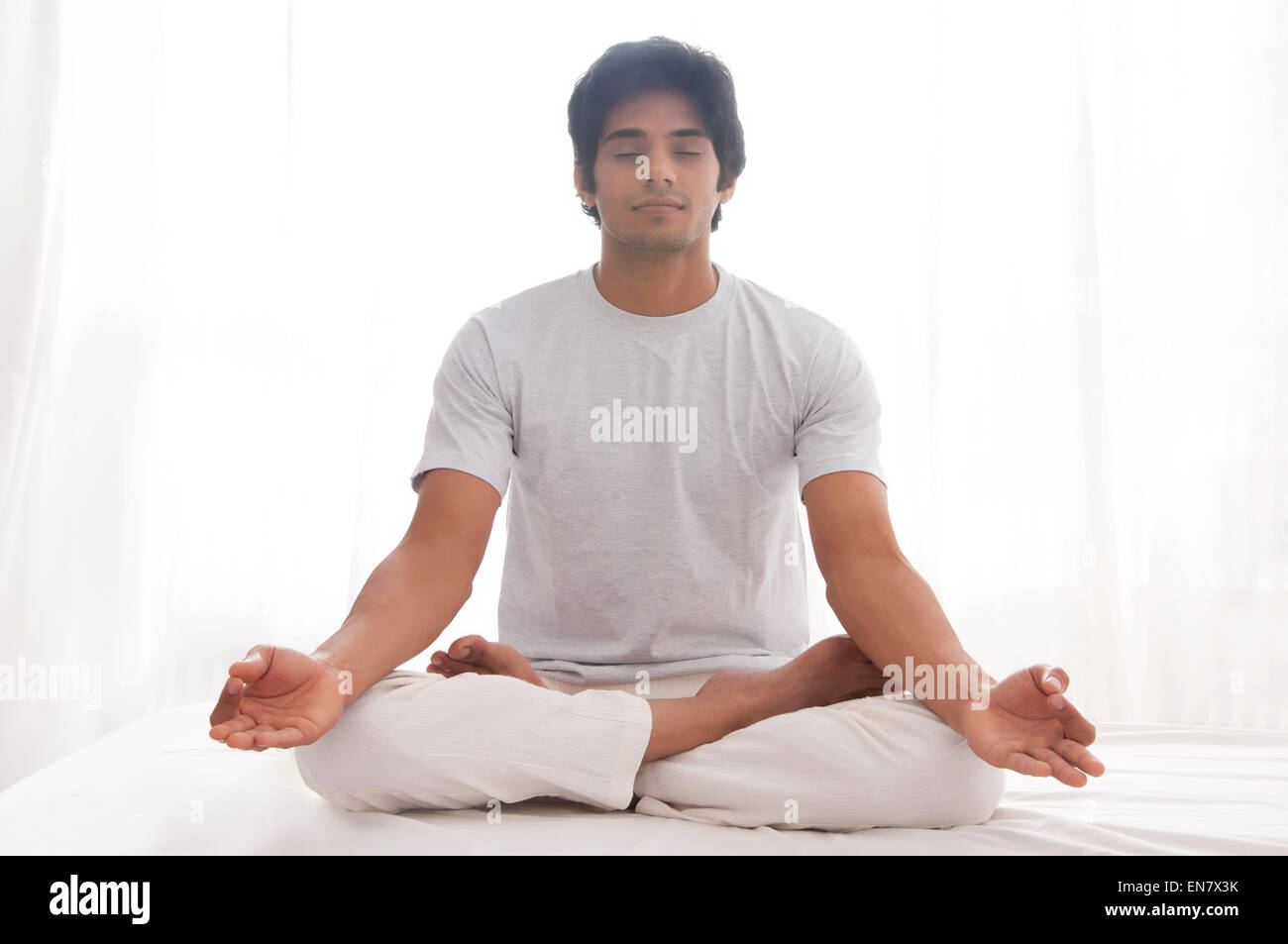 Young man meditating Stock Photo - Alamy