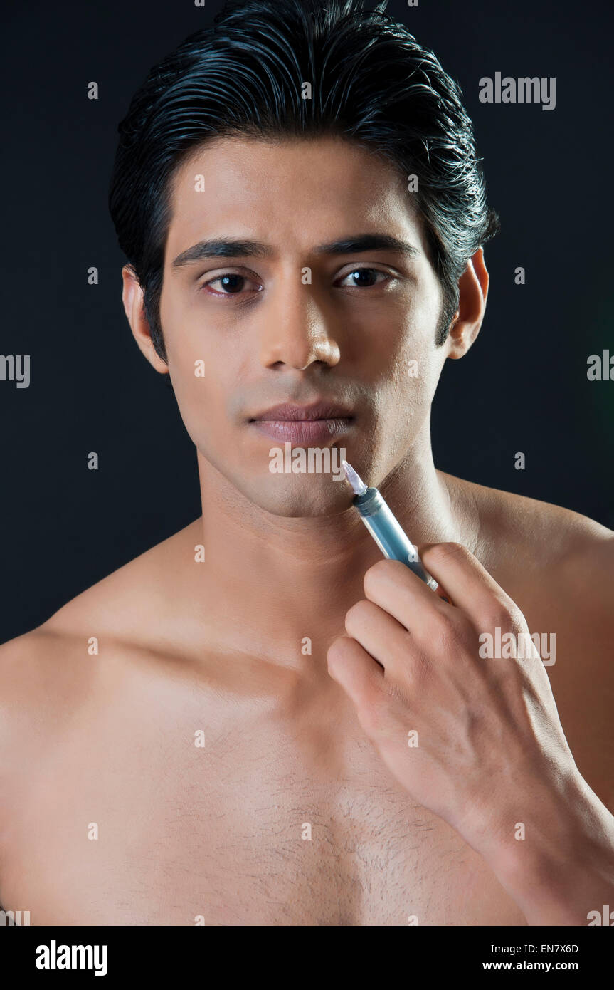Portrait of man giving himself botox injection Stock Photo - Alamy