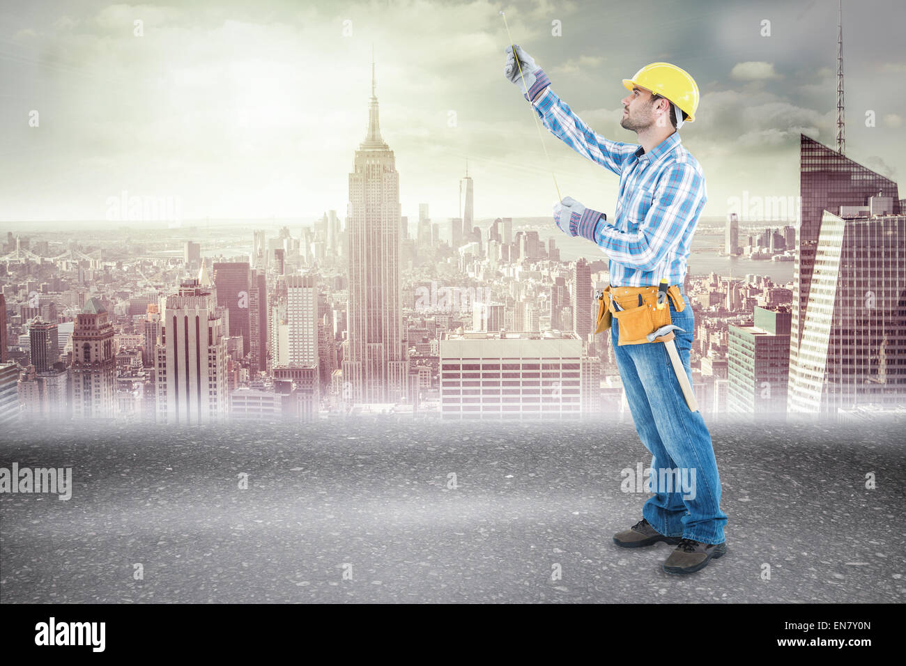 Composite image of construction worker using measure tape Stock Photo ...