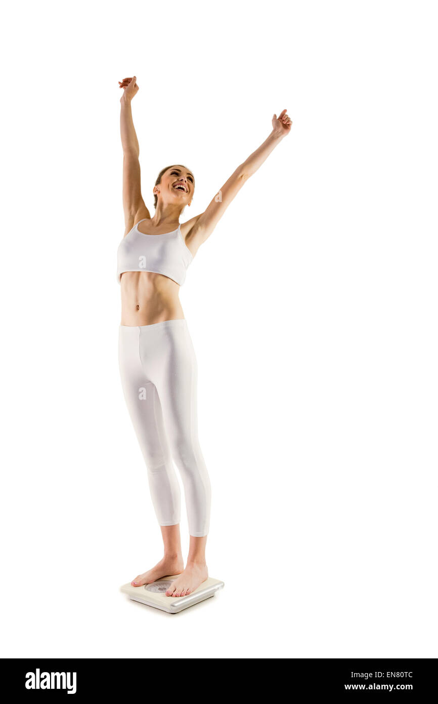 Slim woman cheering on scales Stock Photo - Alamy
