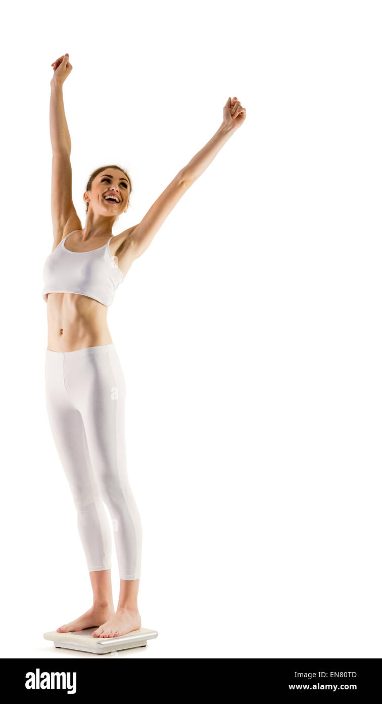 Slim woman cheering on scales Stock Photo - Alamy
