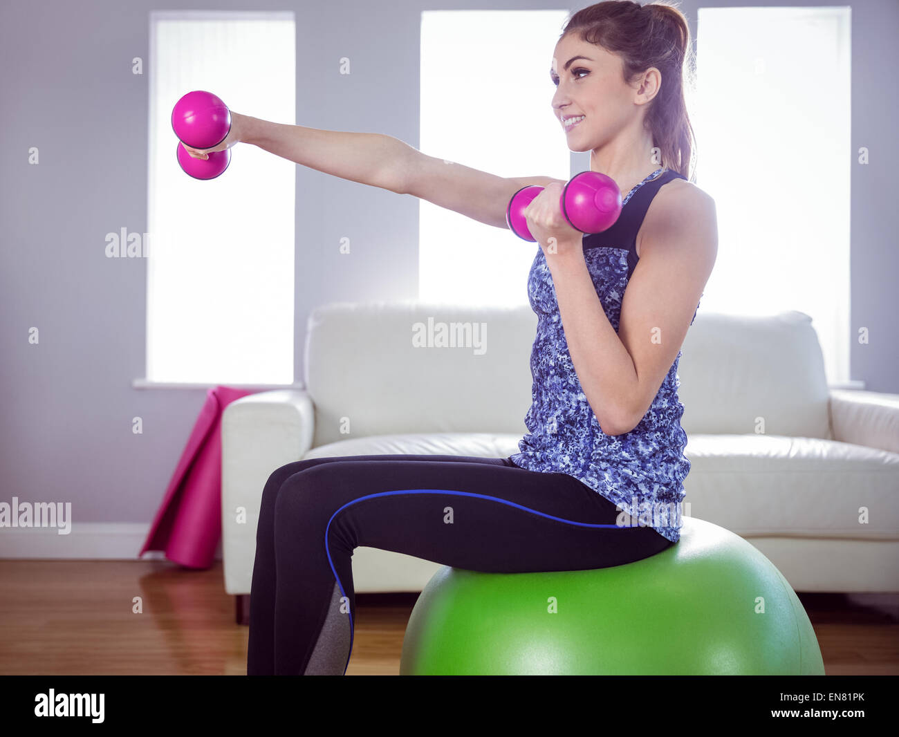 Fit woman lifting dumbbells on exercise ball Stock Photo - Alamy