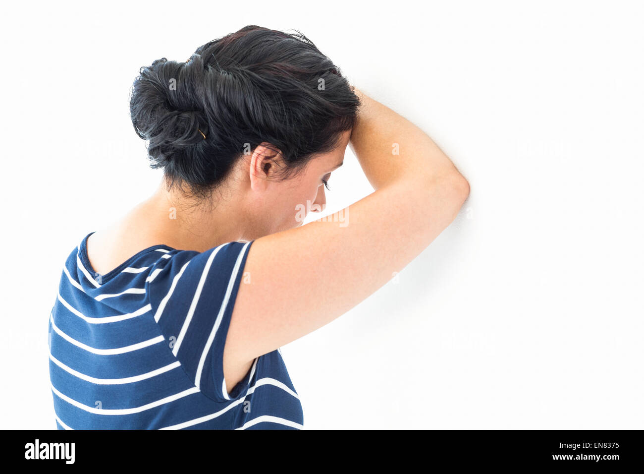 Sad woman leaning against wall hi-res stock photography and images - Alamy