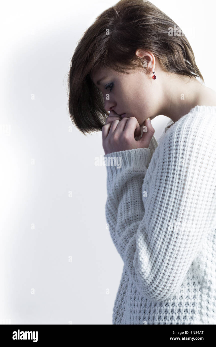 Sad pretty brunette holding her head Stock Photo - Alamy