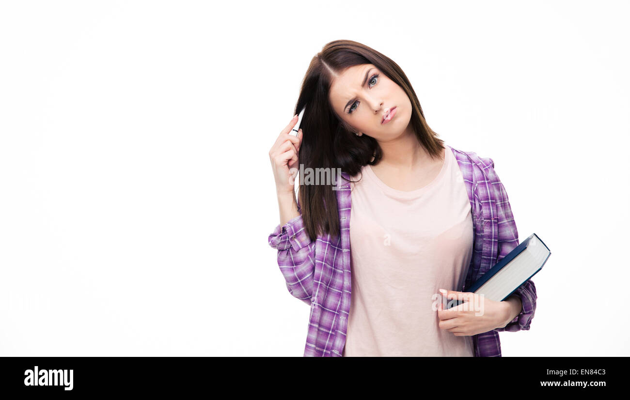 Thoughtful young female student standing with book over white ...