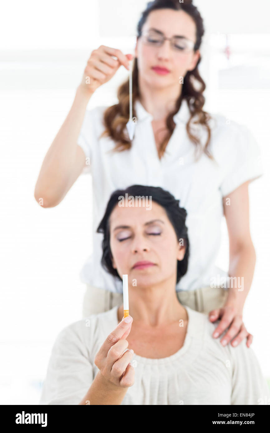 Woman being hypnotized to quit smoking Stock Photo - Alamy