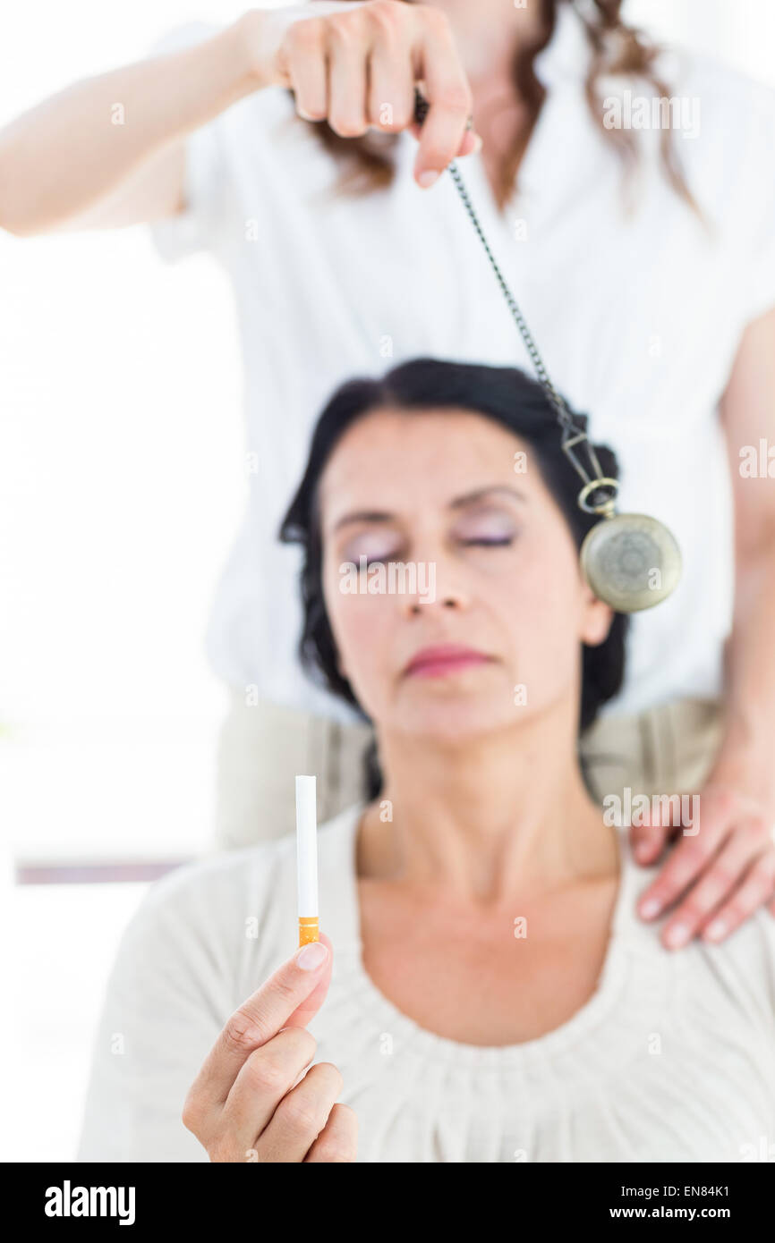 Woman being hypnotized to quit smoking Stock Photo - Alamy