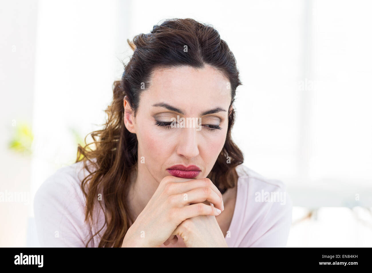 Upset brunette sitting on the couch Stock Photo - Alamy