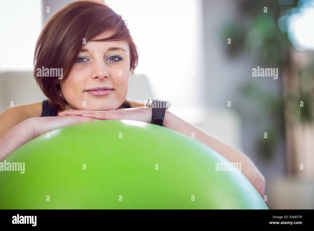 Fit woman leaning on exercise ball Stock Photo - Alamy