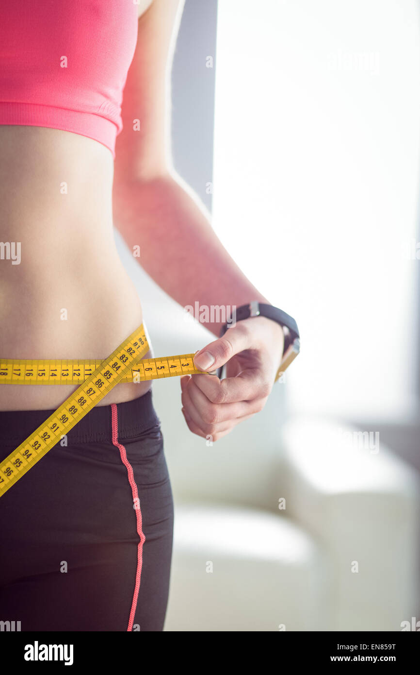 Slim woman measuring waist with tape measure Stock Photo - Alamy