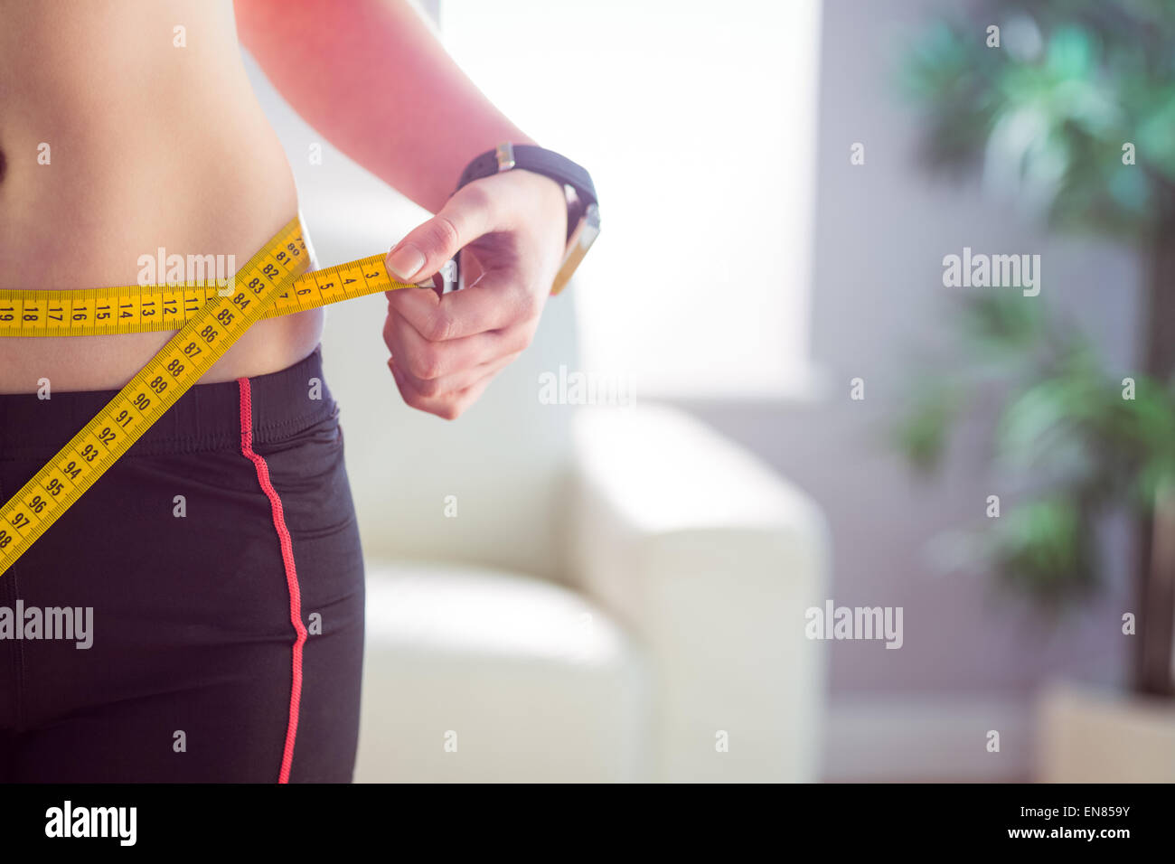 Slim woman measuring waist with tape measure Stock Photo - Alamy