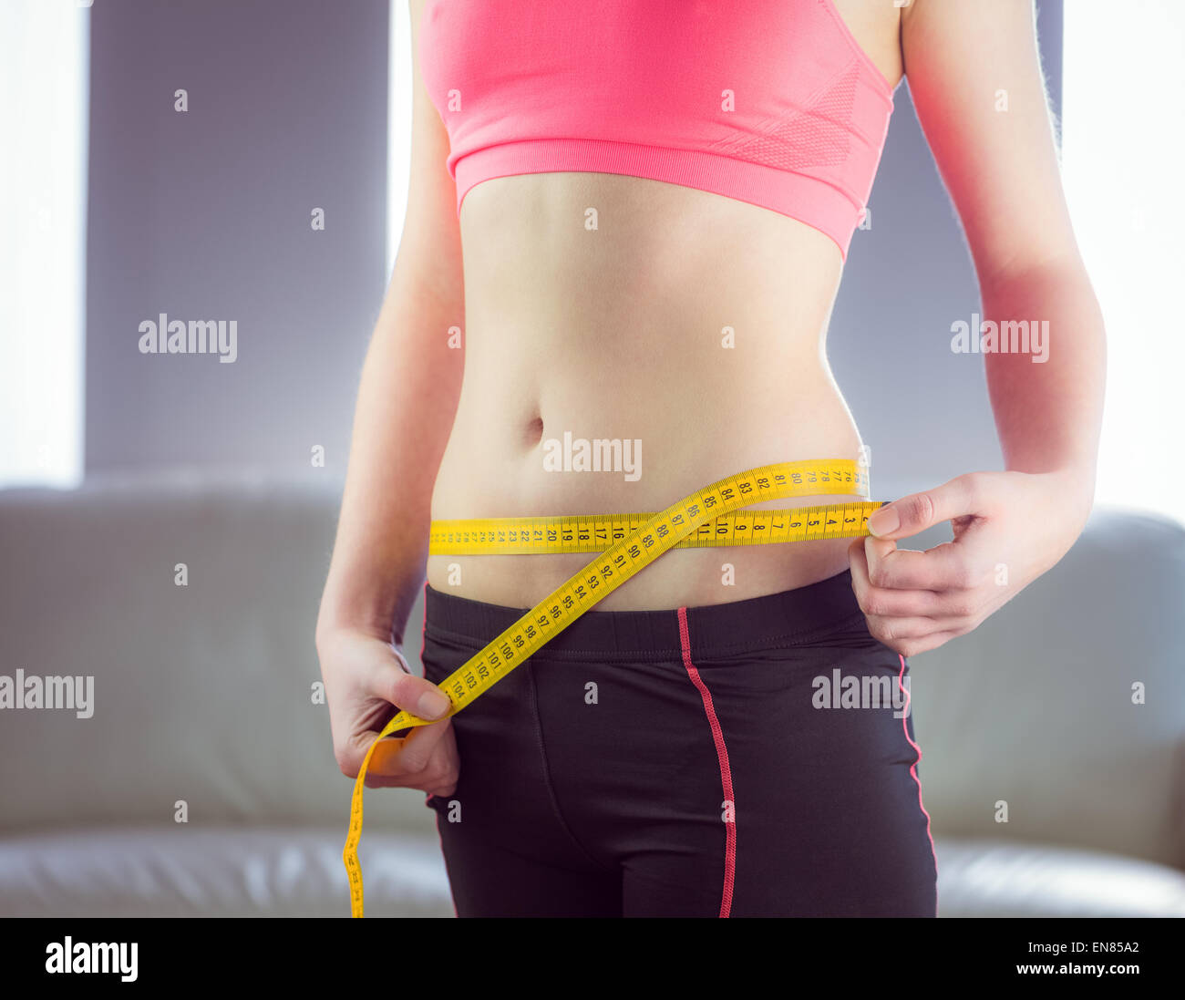 Slim woman measuring waist with tape measure Stock Photo - Alamy