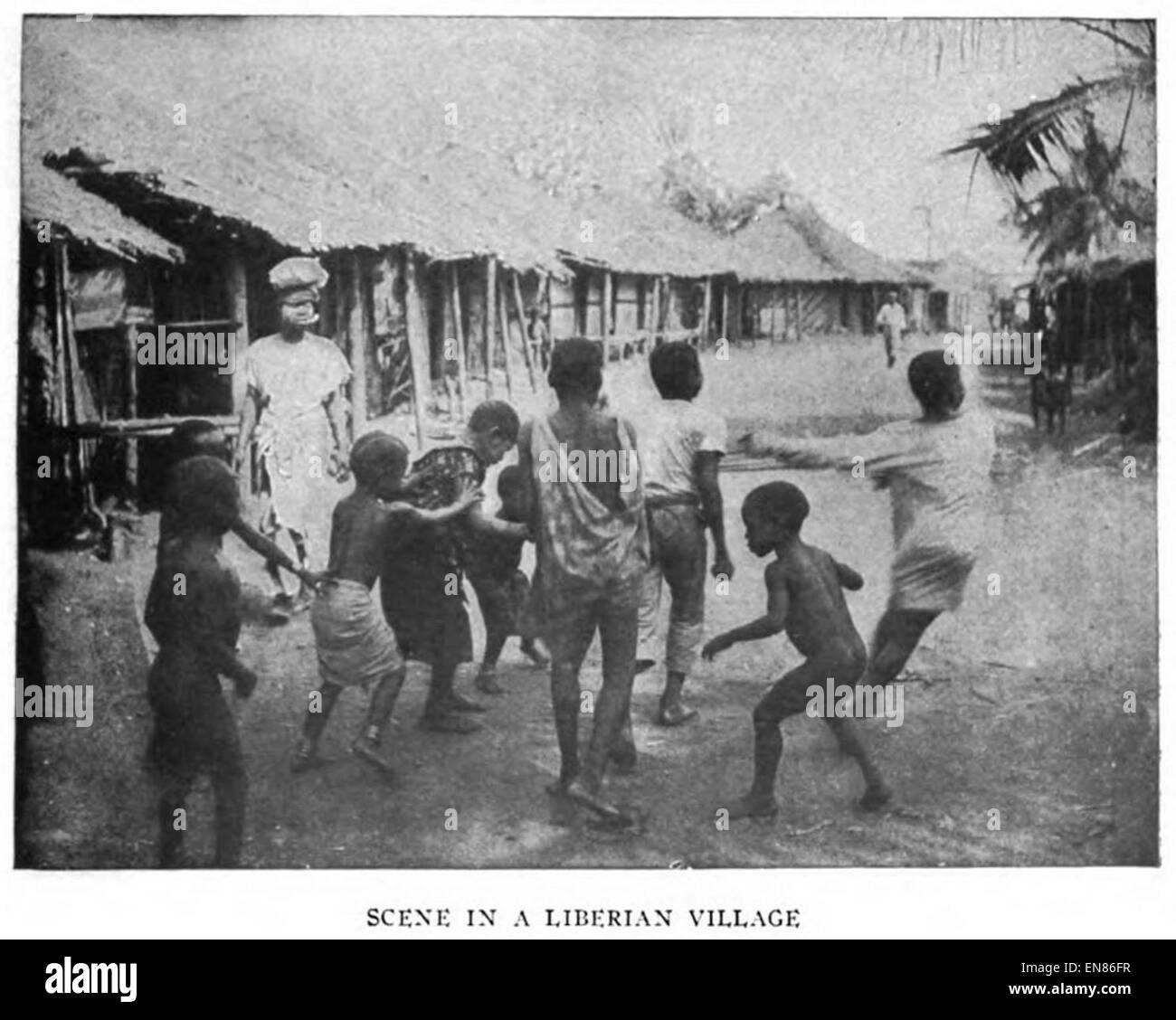 A 1910 photograph capturing daily life in a Liberian village, showing ...