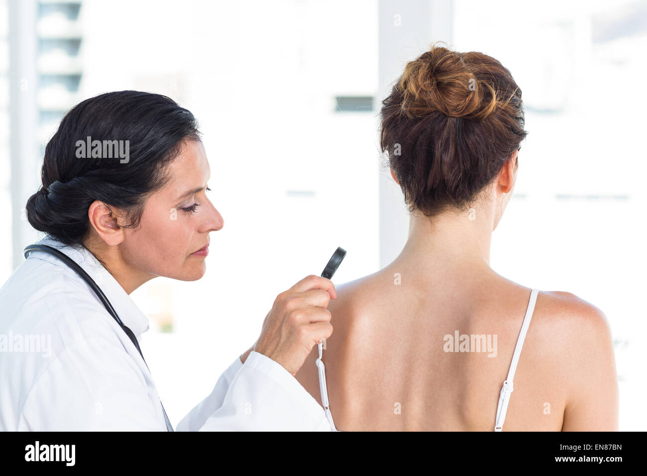 Doctor examining patient with magnifying glass Stock Photo - Alamy