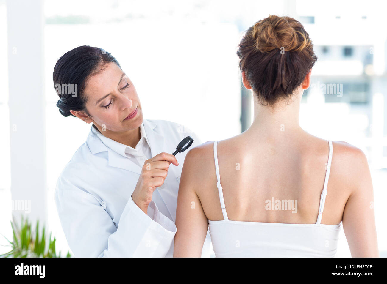 Doctor examining patient with magnifying glass Stock Photo - Alamy
