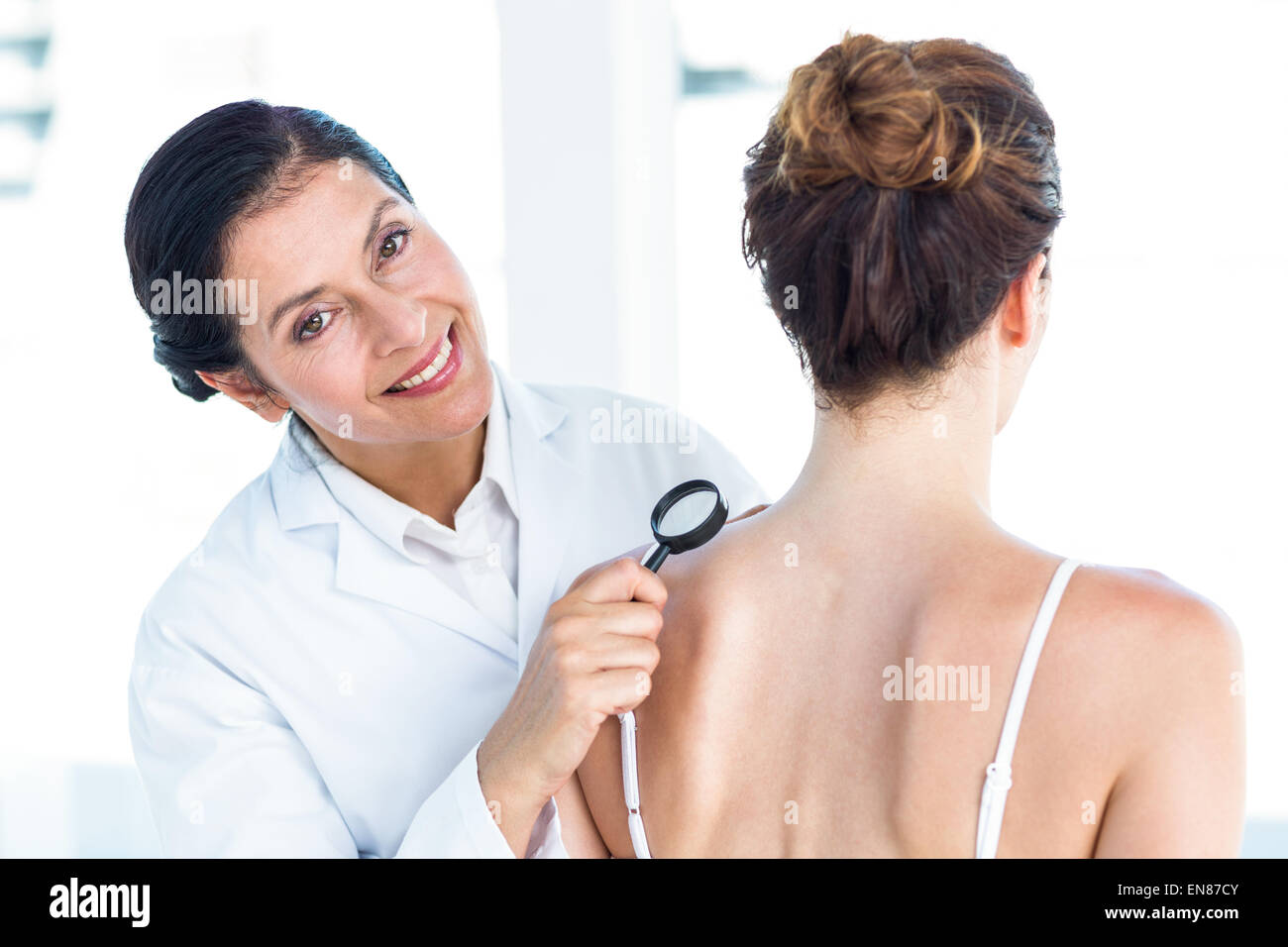 Doctor examining patient with magnifying glass Stock Photo - Alamy