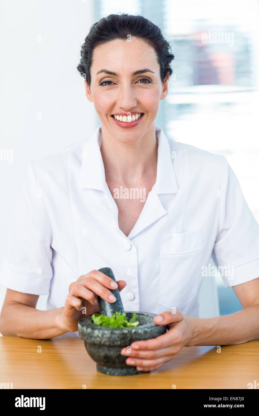Scientist mixing herbs with pestle and mortar Stock Photo - Alamy