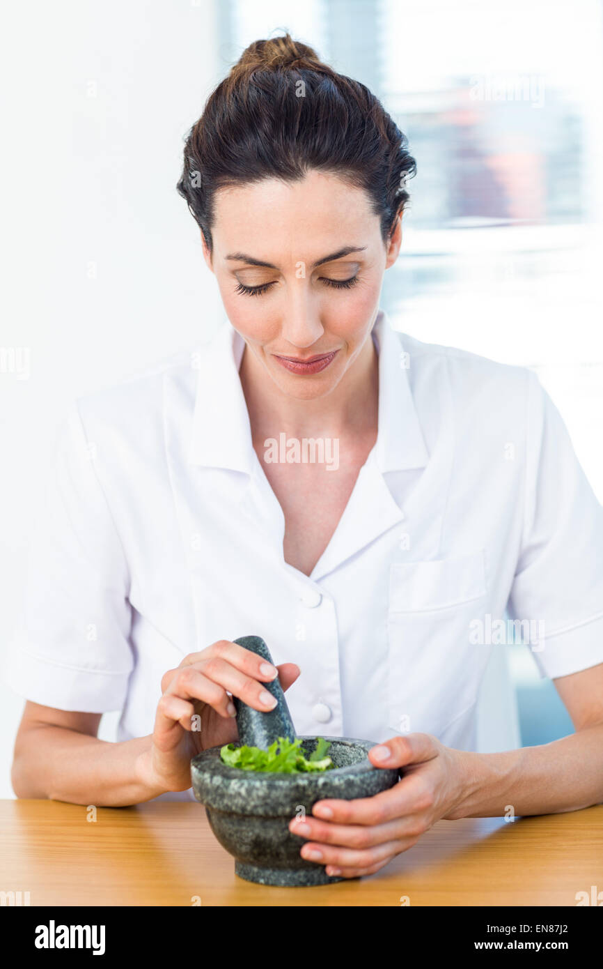 Scientist mixing herbs with pestle and mortar Stock Photo - Alamy