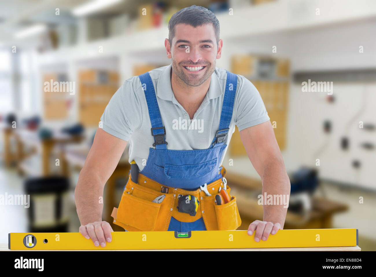 Composite image of worker using spirit level Stock Photo - Alamy