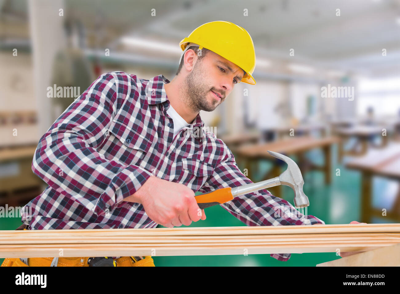 Composite image of handyman using hammer on wood Stock Photo - Alamy